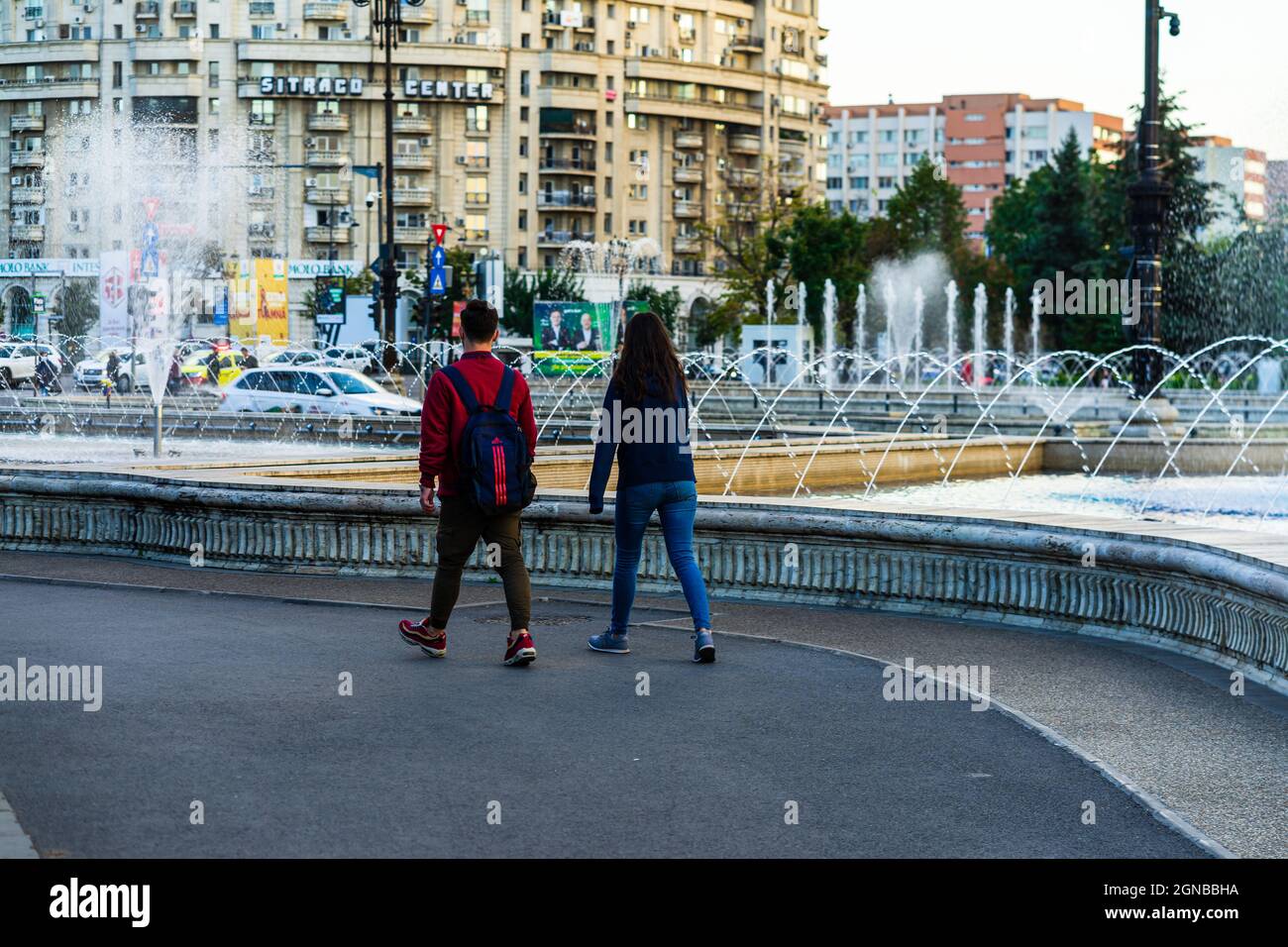 Teenagers, boy and girl walking on street in downtown of Bucharest ...