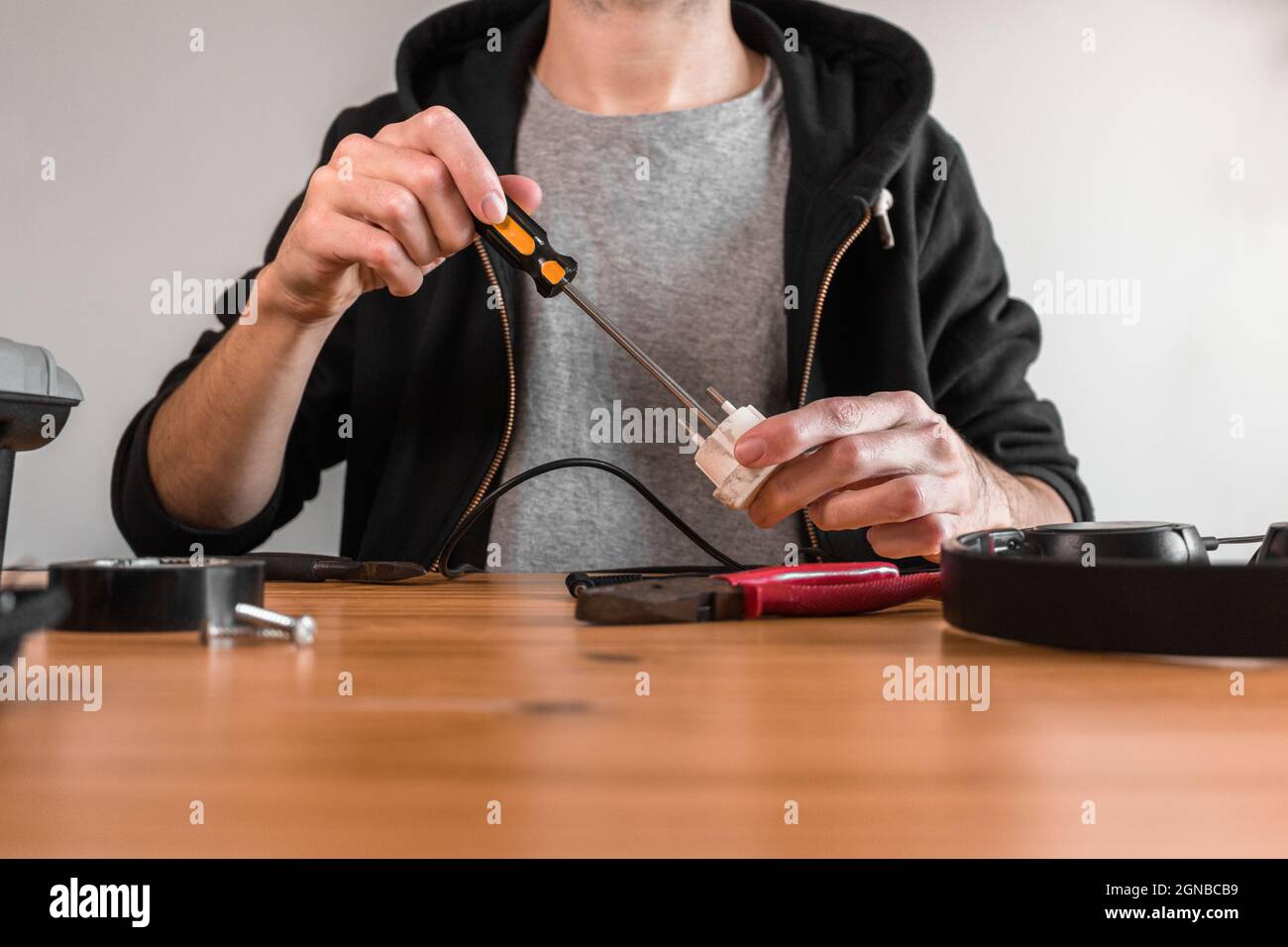 Man at home with screwdriver opening an electrical adapter Stock Photo ...