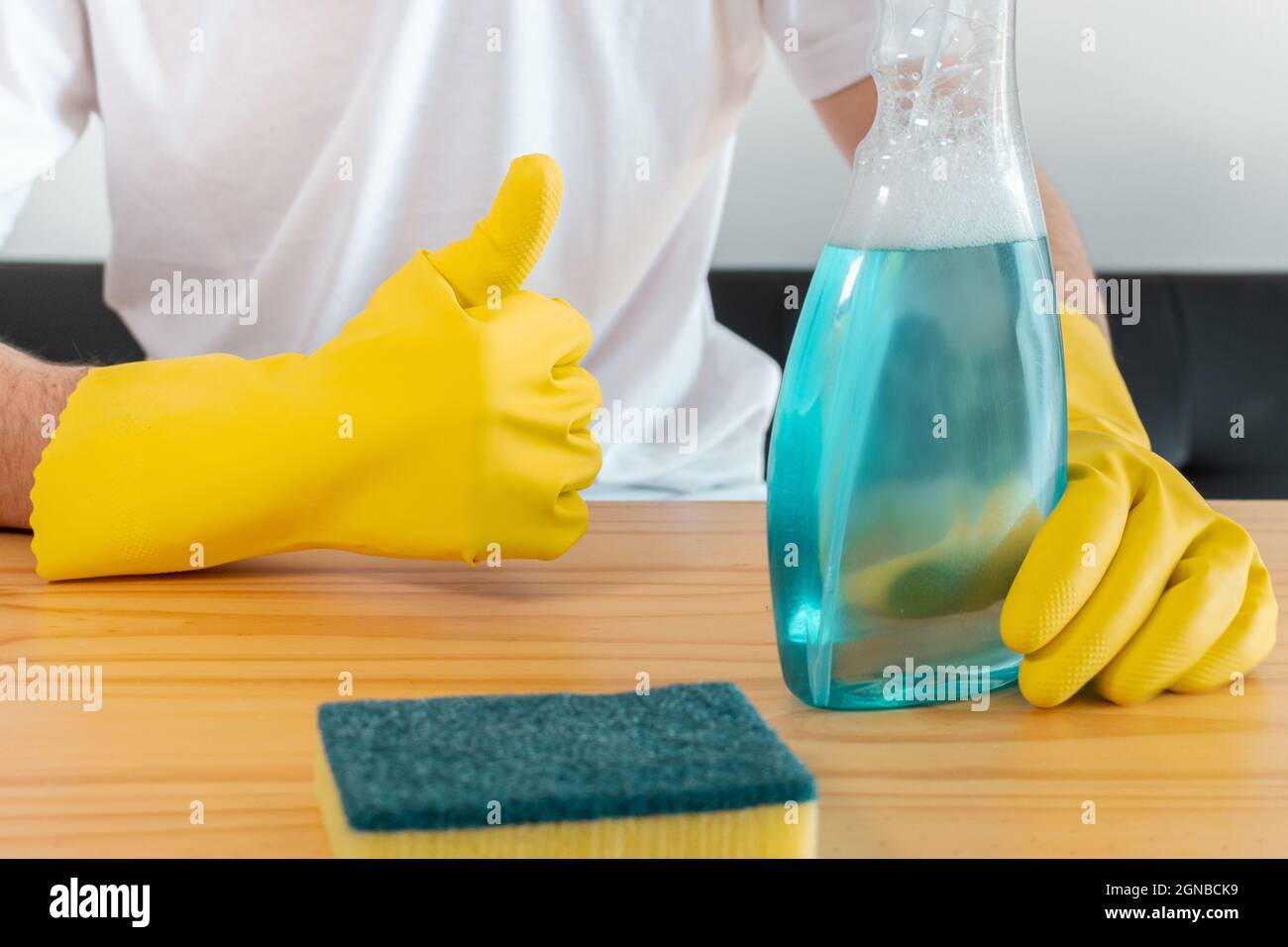 Man hands with yellow gloves making ok sign and holding cleaning ...