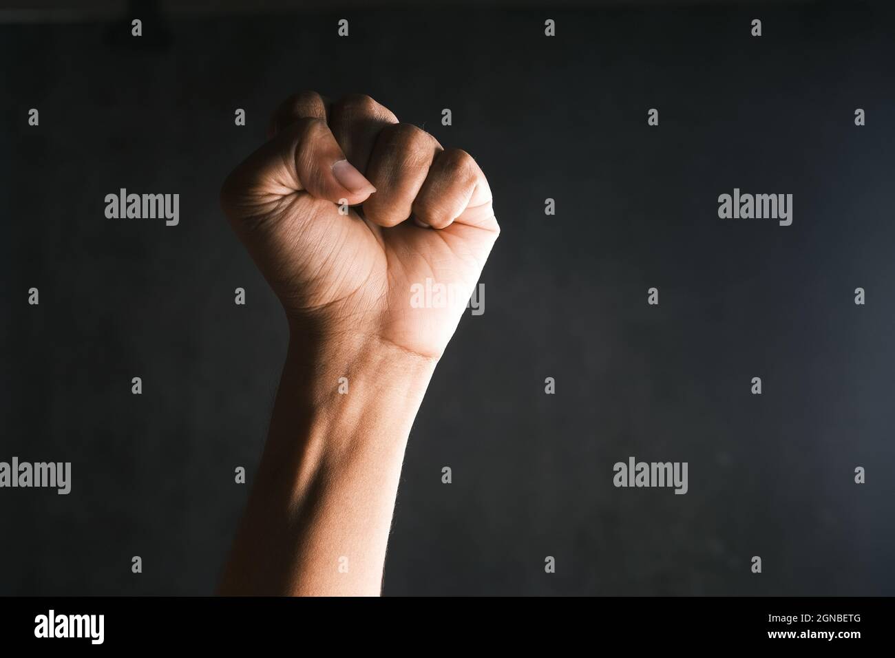 hands clenched power strength isolated on black Stock Photo - Alamy