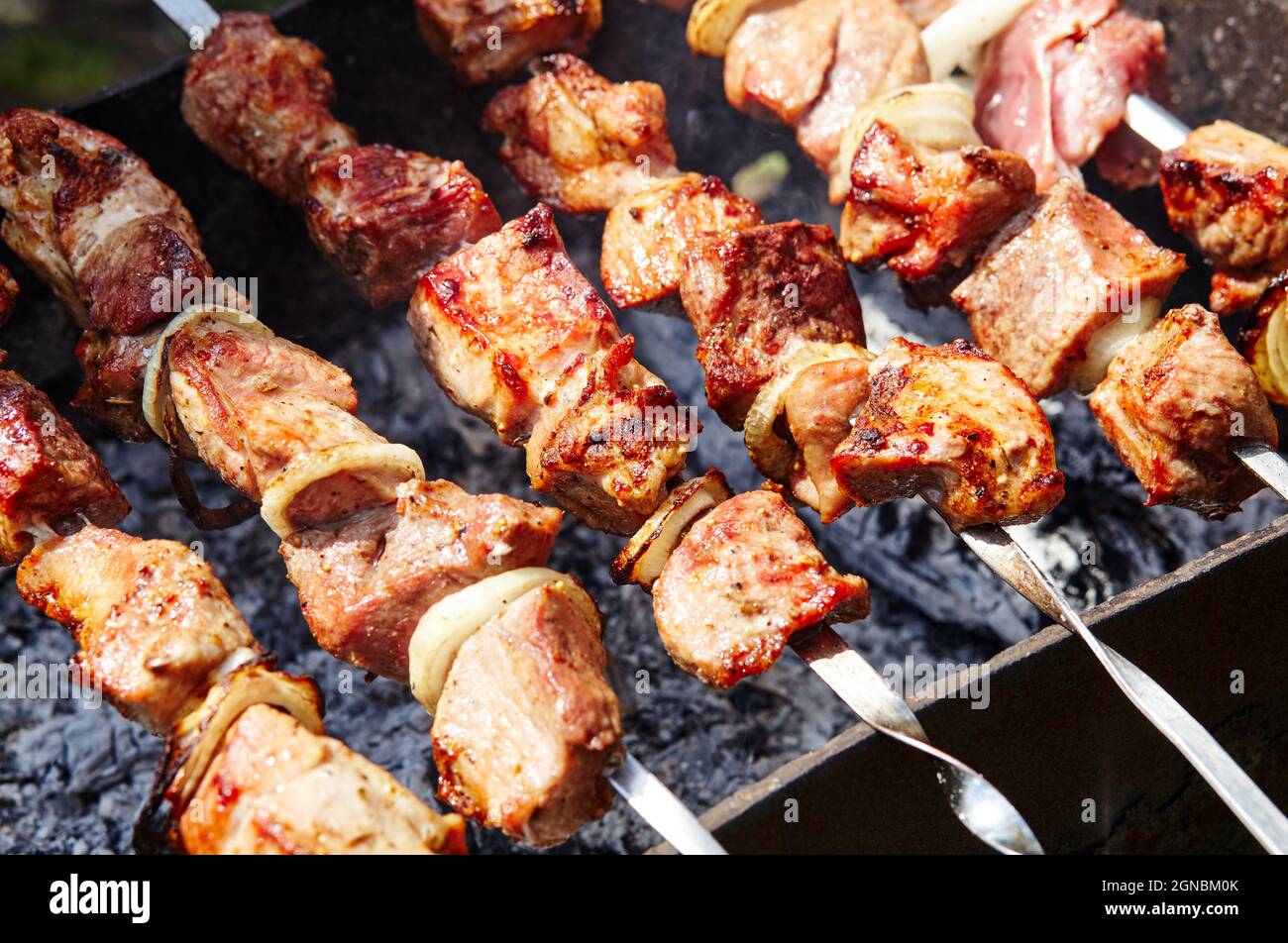 Marinated shashlik preparing on a barbecue grill over charcoal ...