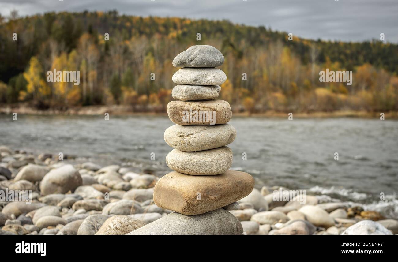 Pile of stones built in cairn on the background of river. Concept of ...