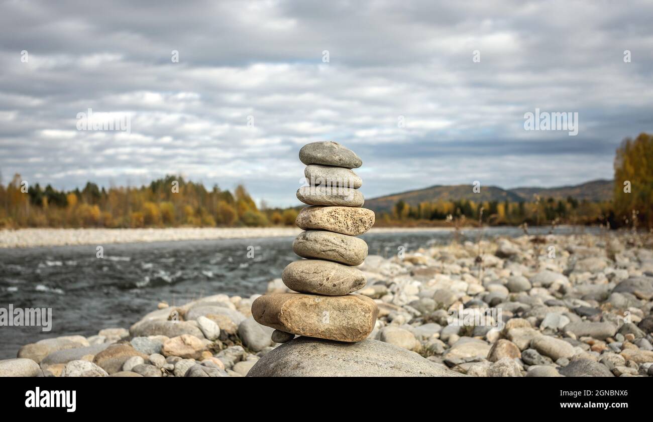 Pile of stones built in cairn on the background of river. Concept of ...