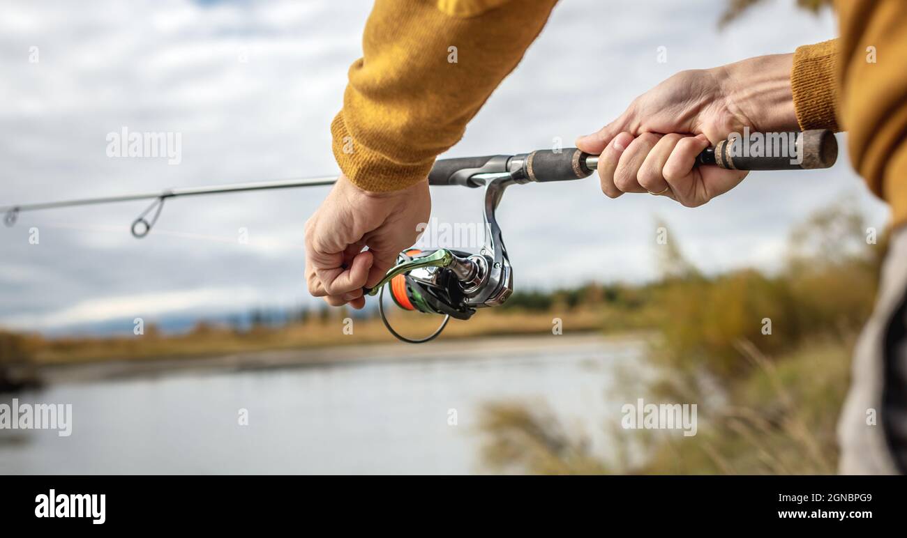 Male hands of a fisherman are holding a spinning closeup. Concept of ...