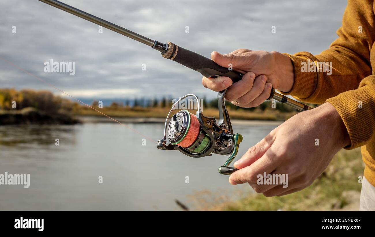 Male hands of a fisherman are holding a spinning closeup. Concept of ...