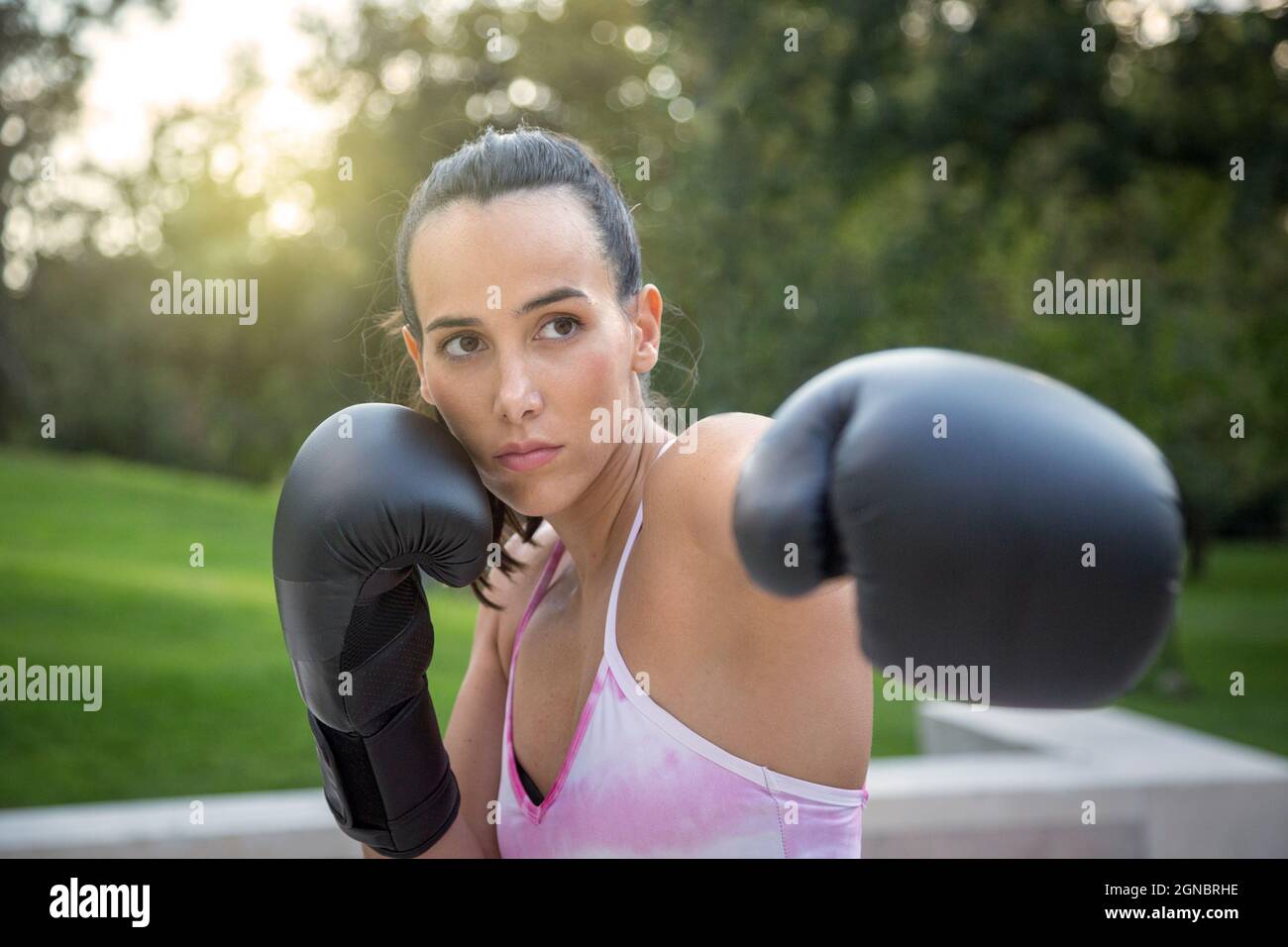 Young caucasian woman giving a punch with boxing gloves Stock Photo - Alamy