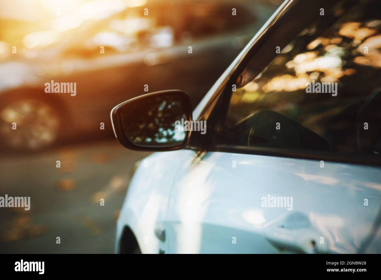A blurry image of the rear-view mirror on a white car and a beautiful ...