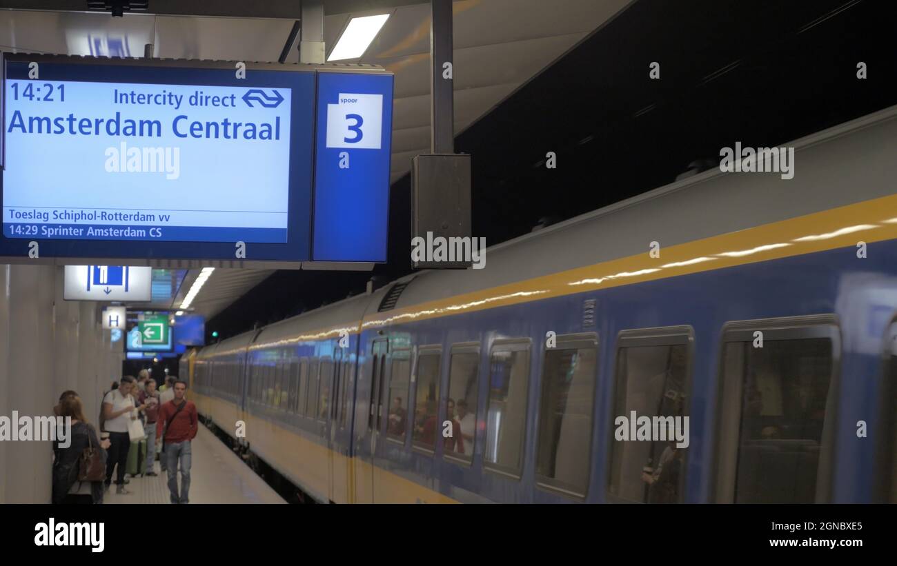 Trains and passengers at railway station of Amsterdam Airport Stock Photo - Alamy