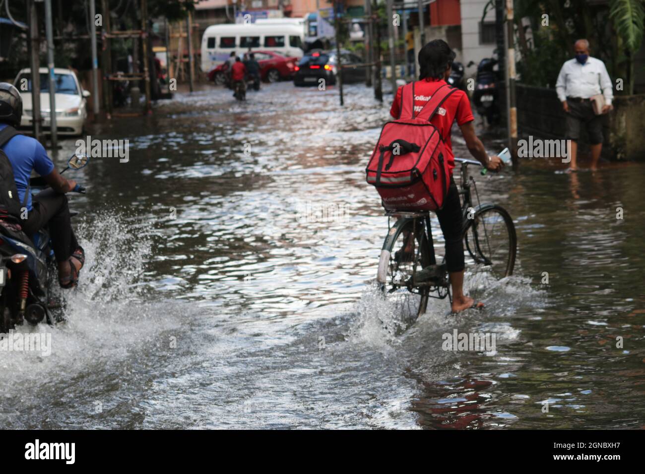 A Zomato food delivery boy cycling his way through a waterlogged street ...
