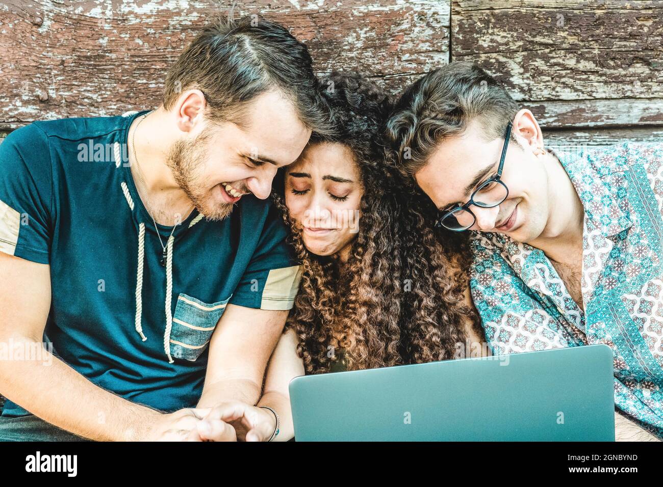 Multiracial friends having fun with laptop during a video call outdoors ...
