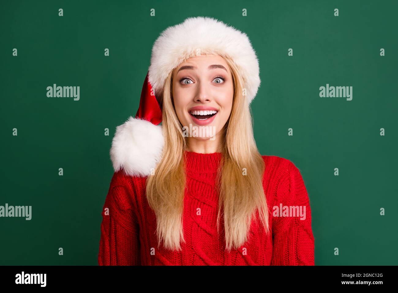 Photo portrait blonde woman in santa hat smiling amazed isolated green ...