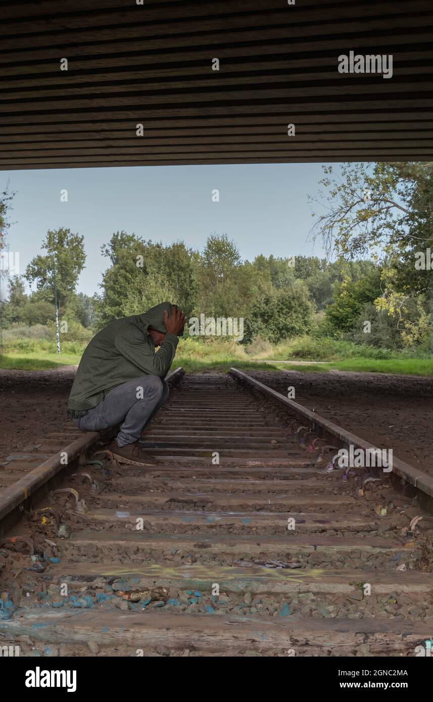 man sitting on a railway track Stock Photo - Alamy