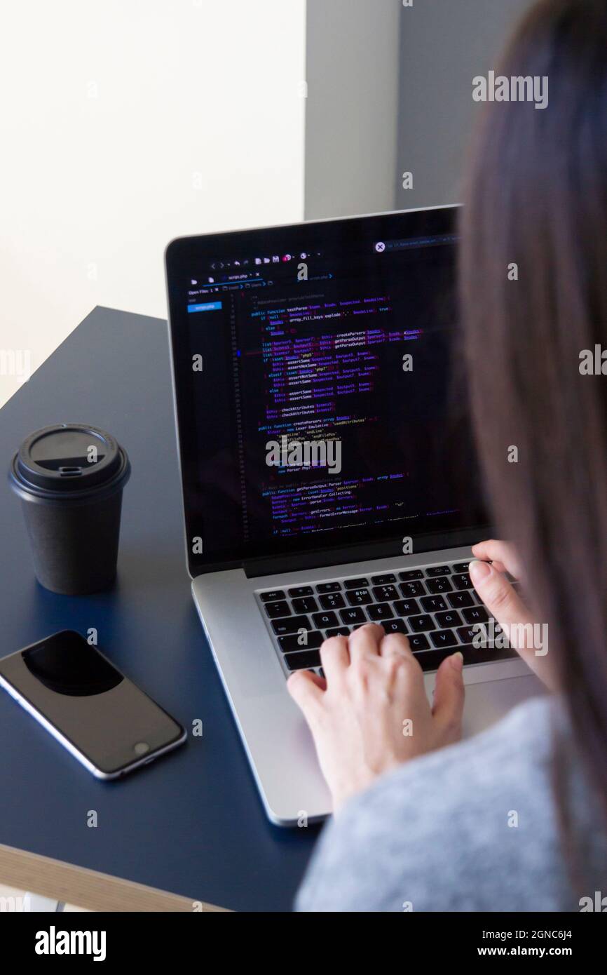 A programmer coding on a laptop in the workplace Stock Photo - Alamy