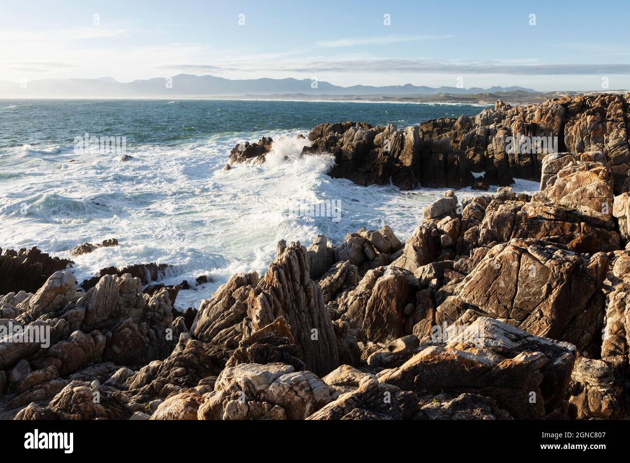 The jagged rocks and rock pools on an ocean coastline with waves ...