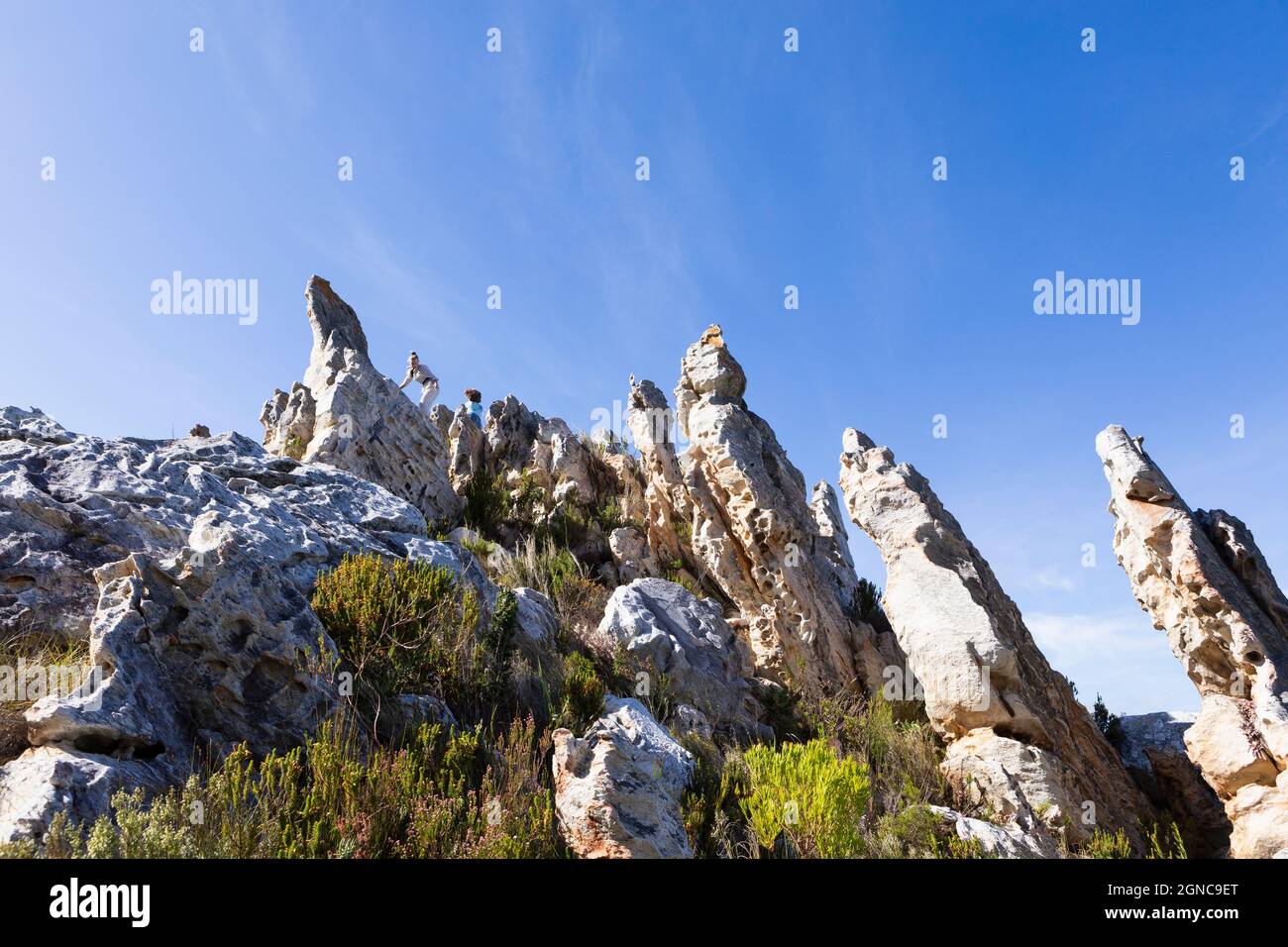 Two children climbing on top of large sandstone rock formations on a ...