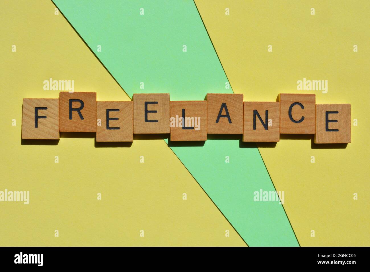 Freelance, word in wooden alphabet letters isolated on yellow and green ...