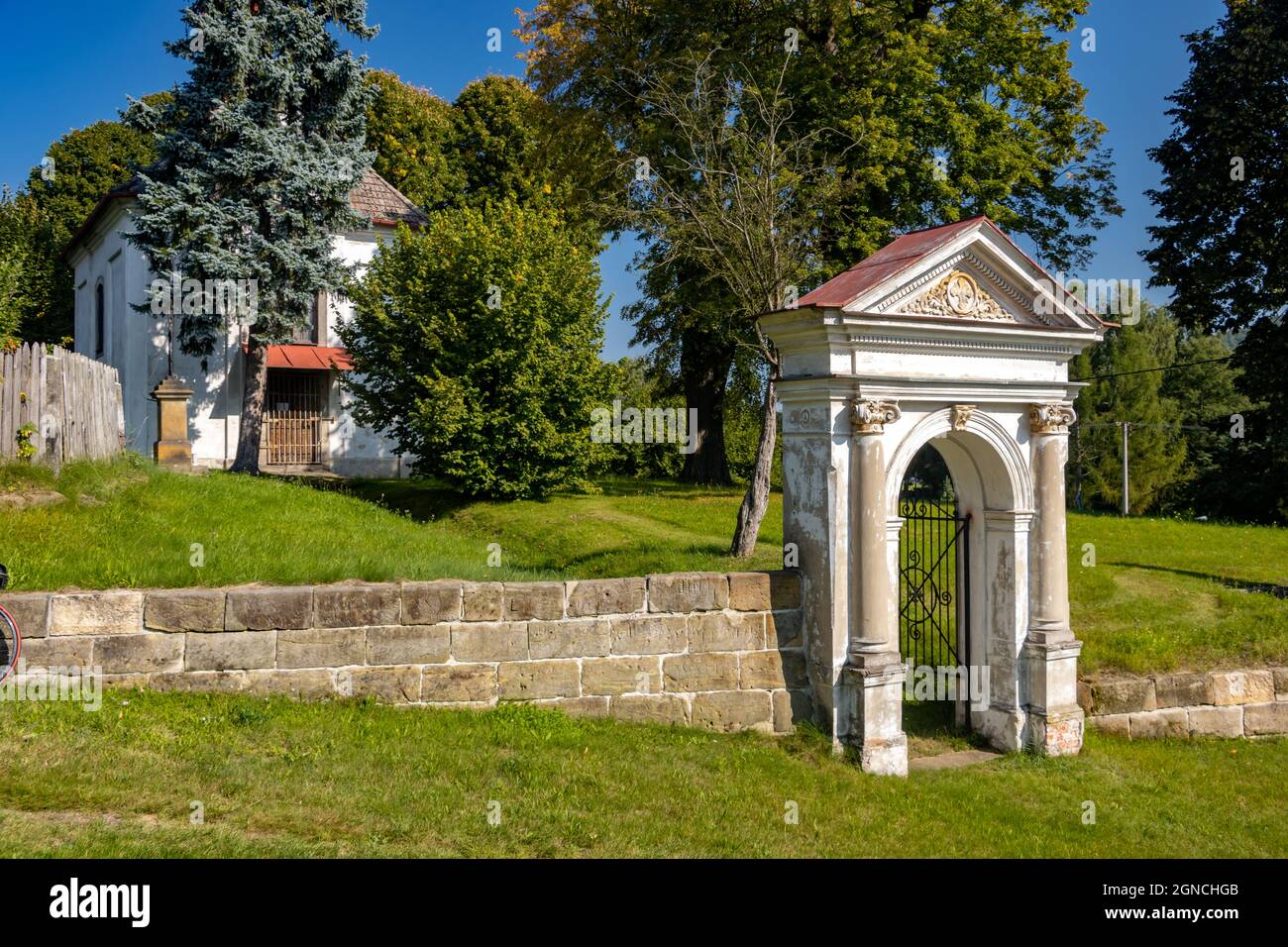 Classicist gate at the entrance to a country cemetery with a baroque ...