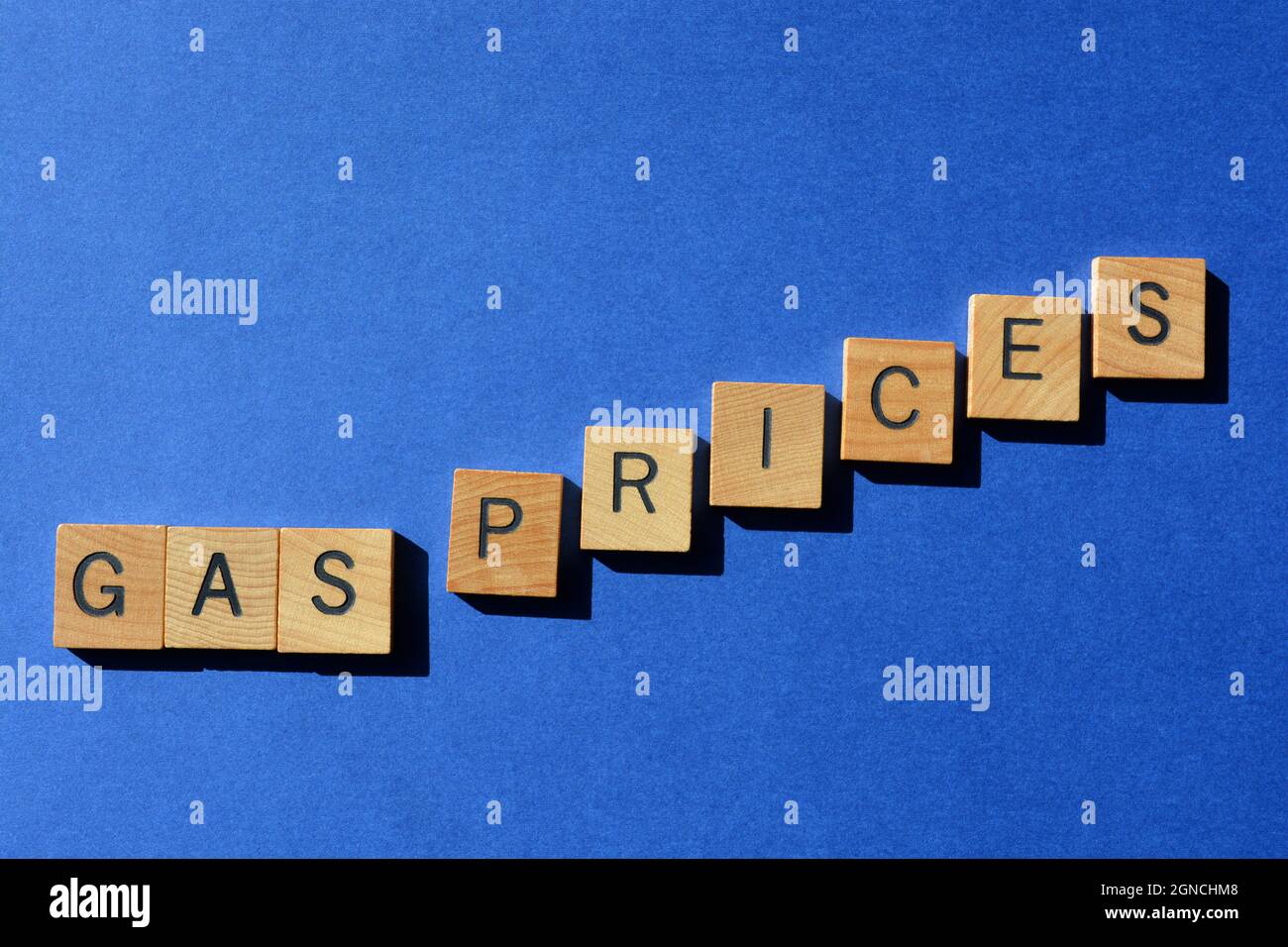 Gas Prices, rising words in wooden alphabet letters isolated on blue ...