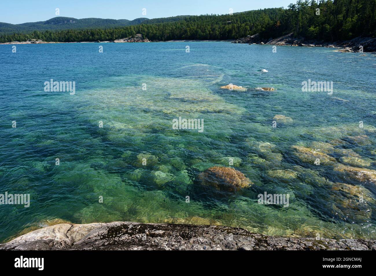 Rocks can be seen under the clear water of Lake Superior along the ...
