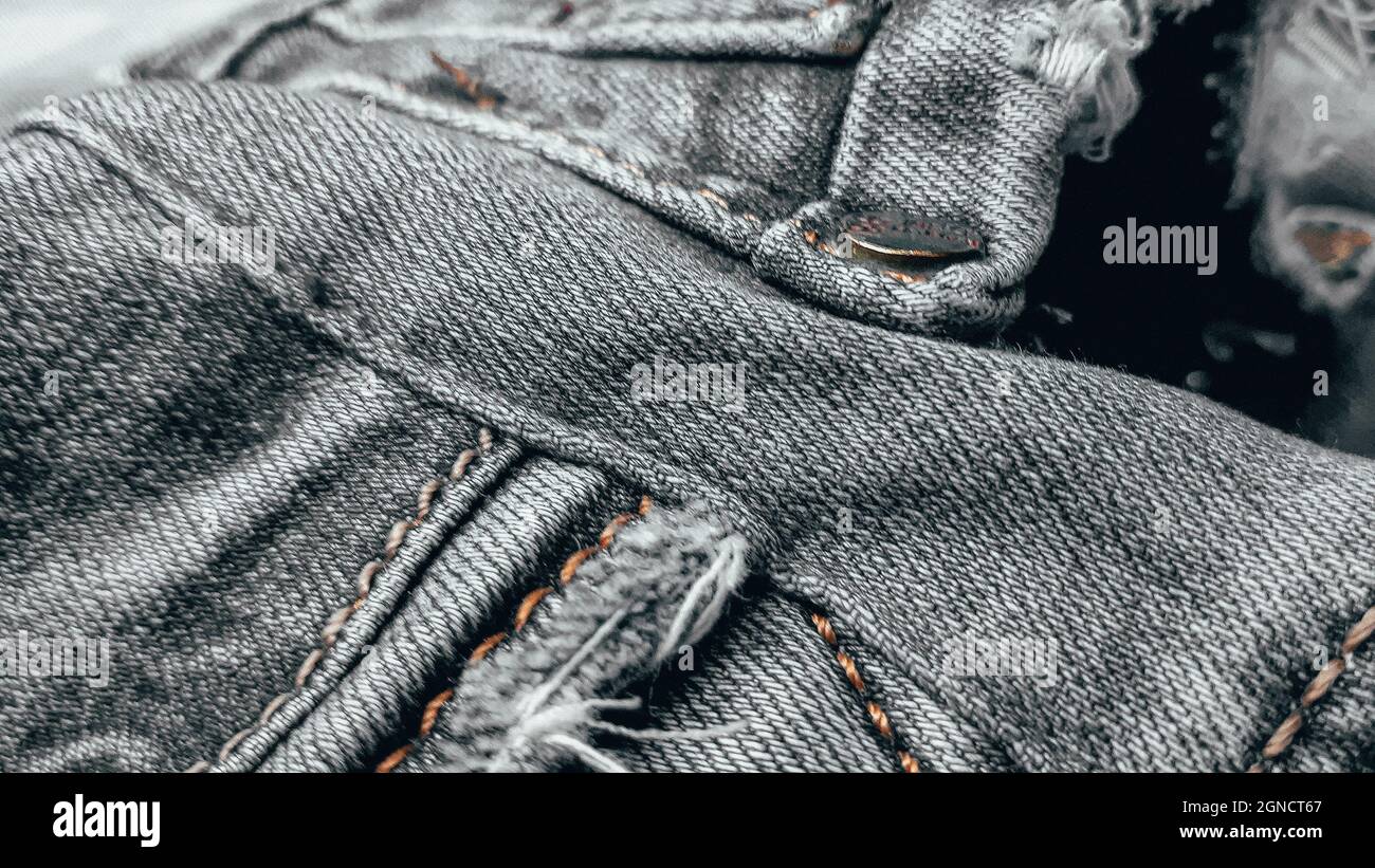 texture of grey cotton fabric with gold threads and a pocket on jeans ...
