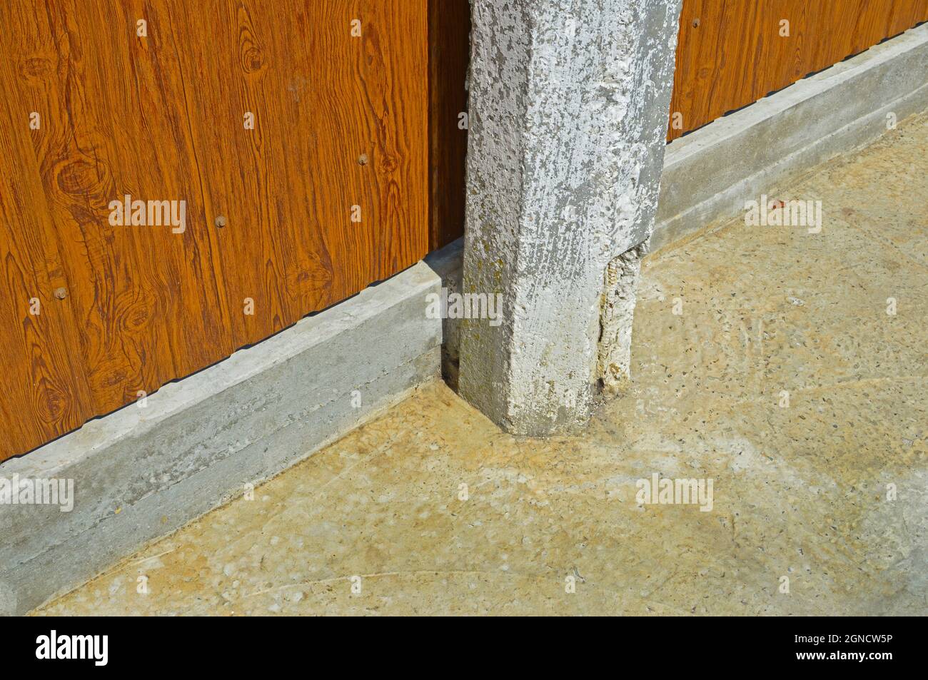 The hexagonal concrete column is concreted in the sidewalk near a metal ...