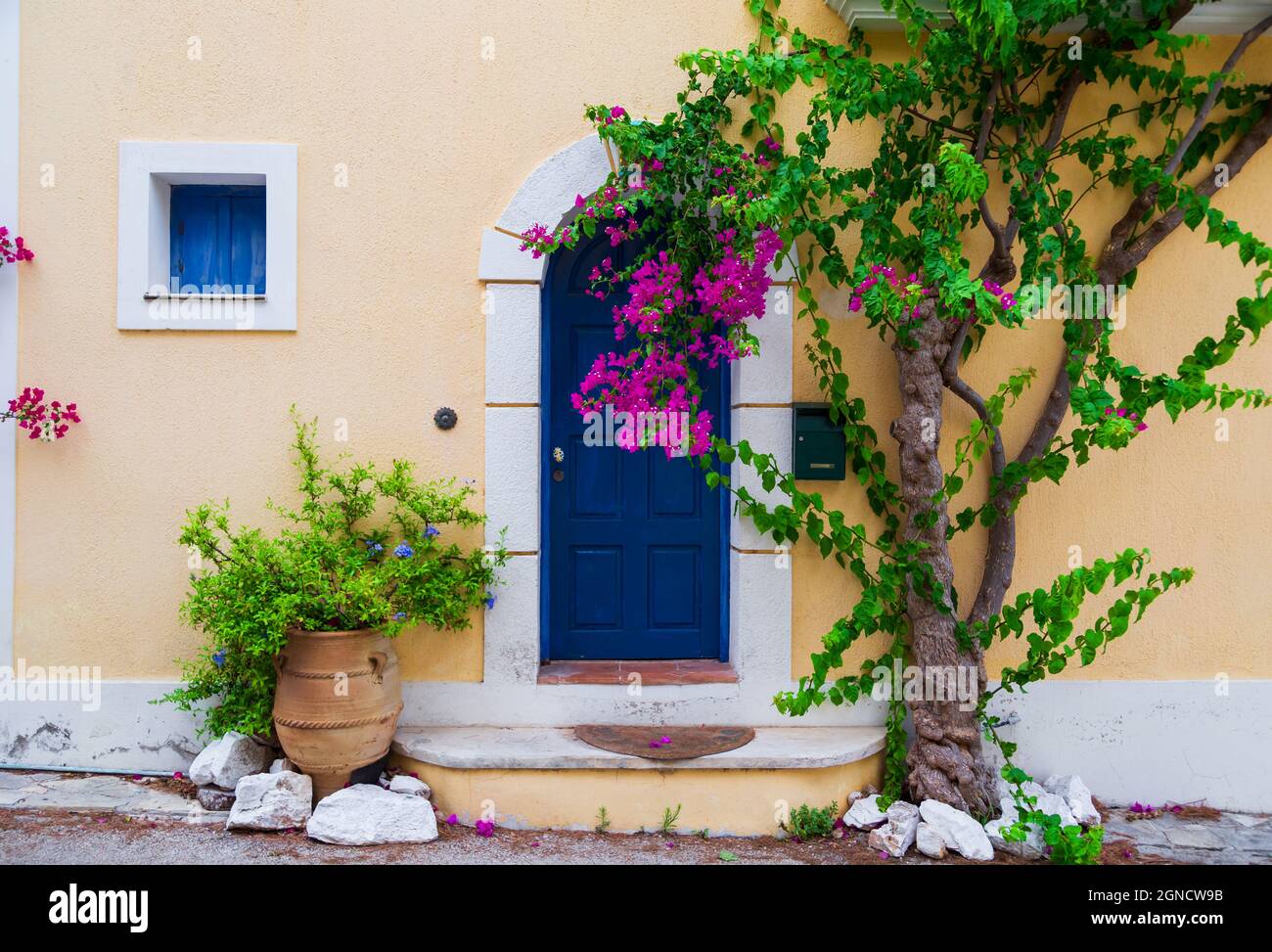 Colorful blue door of traditional greek house with yellow walls at Asos ...