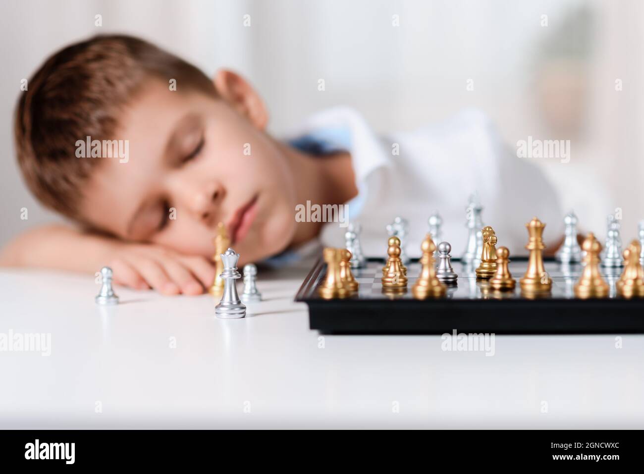 The child played chess and fell asleep at the table at home Stock Photo ...