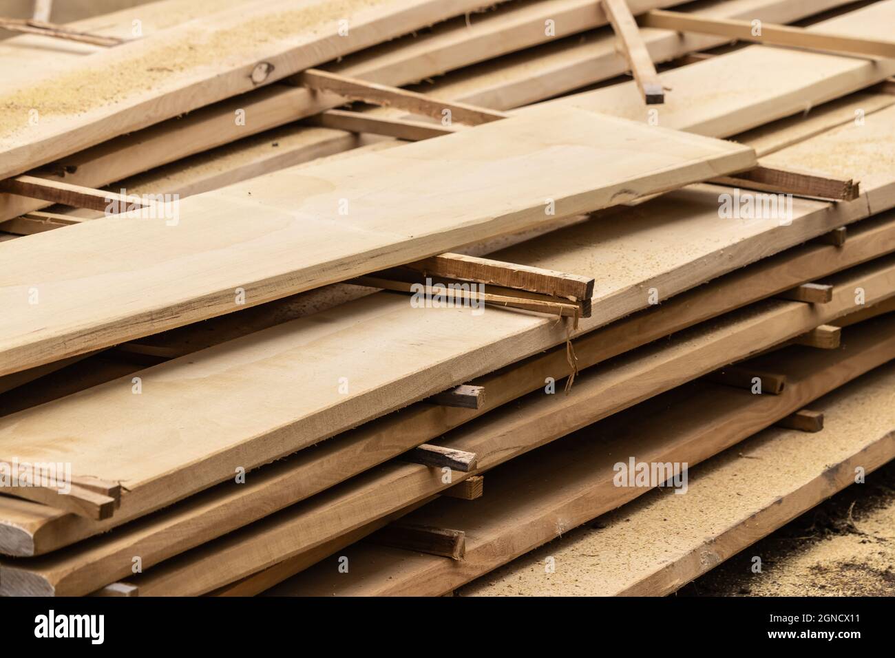 Closeup of a pile of lumber wood on the grassy ground in the garden ...