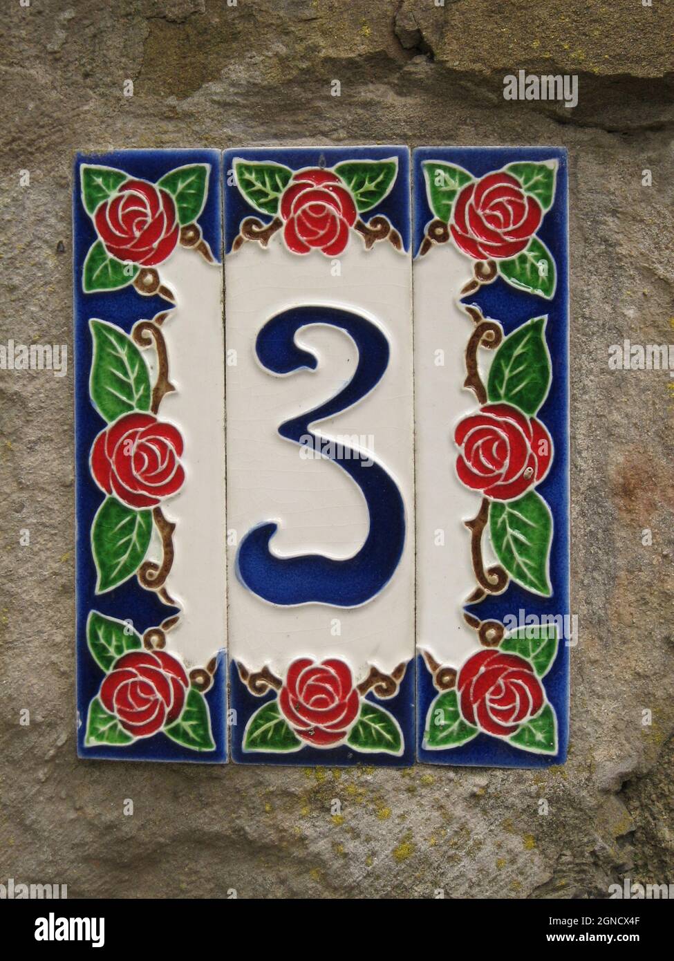 View of a tile with a floral frame and the number 3 inside of it on the ...