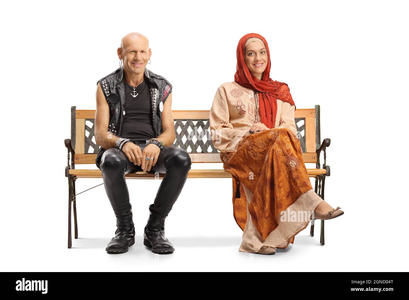 Young woman wearing a hijab and a bald punk man sitting on a bench ...