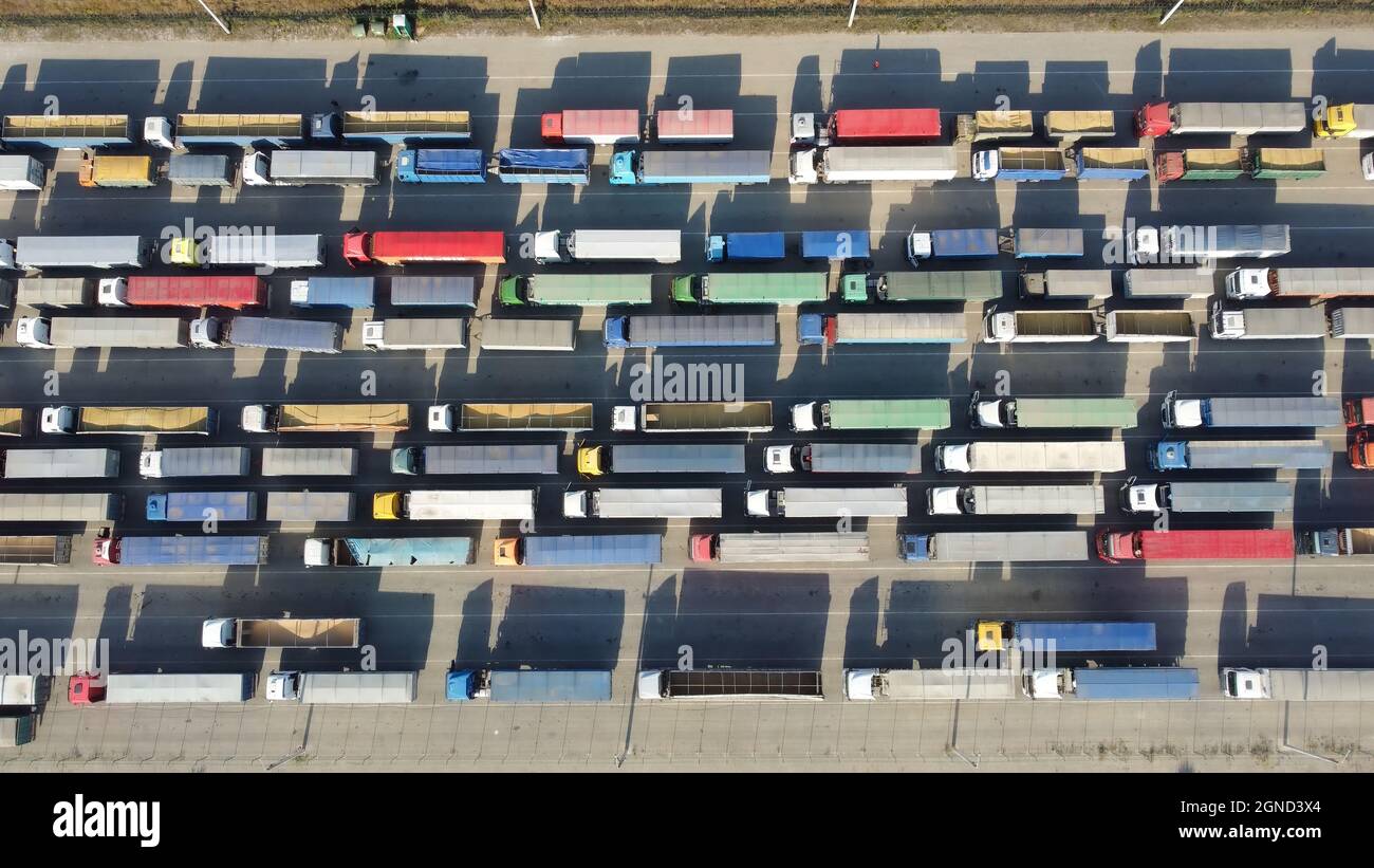Lots of trucks in the port terminal. Top view of loaded containers and ...