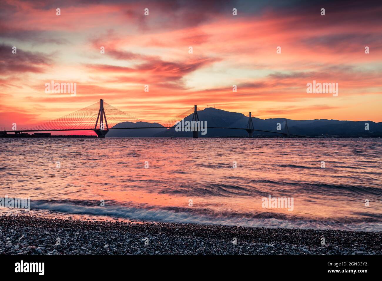Dramatic red sky under a Rion-Antirion Bridge. Colorful spring scene on ...