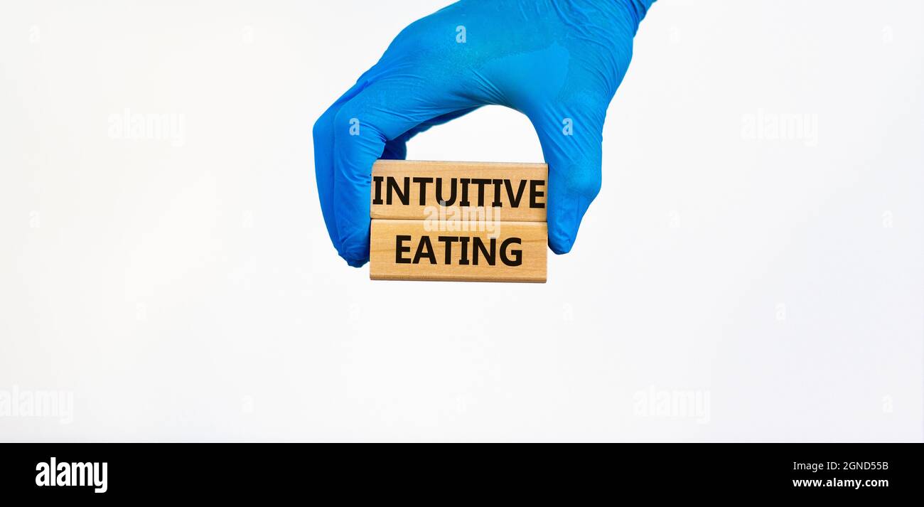 Intuitive eating symbol. Doctor hand in blue glove holds wooden blocks ...