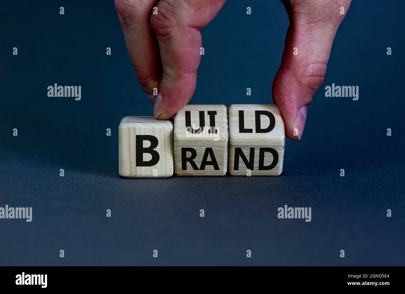 Build your brand symbol. Businessman turns wooden cubes and changes the ...