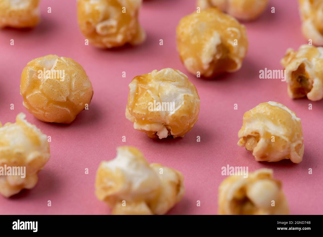 Toffee popcorn on a bright pink background in an abstract layout Stock ...