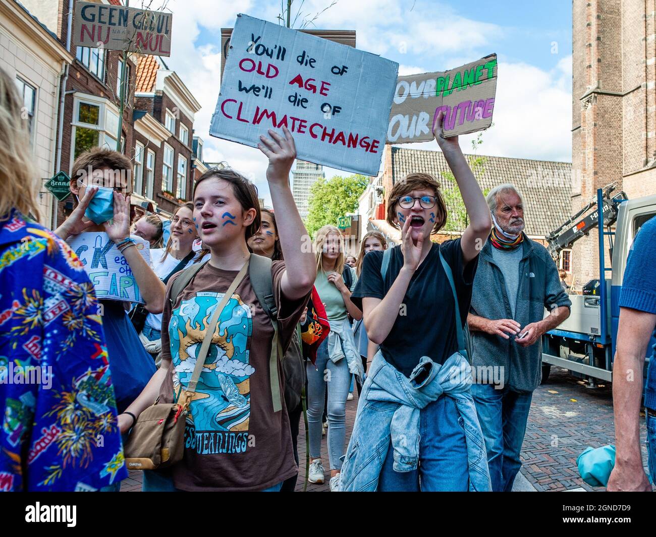 A woman chants slogans while holding a placard in support of the planet ...