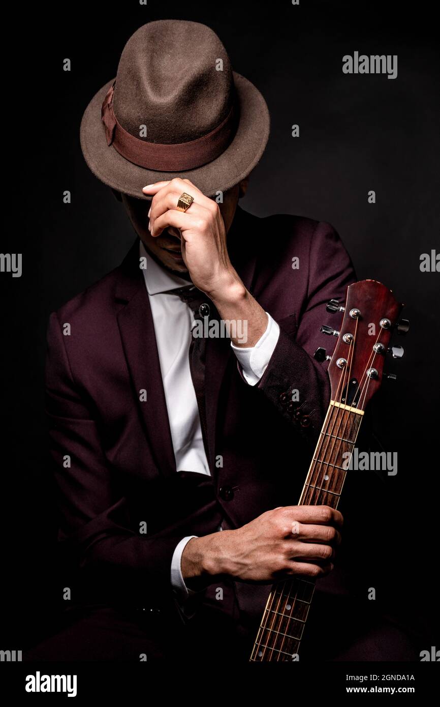 Caucasian man from Spain in suit with hand on hat and holding a guitar ...