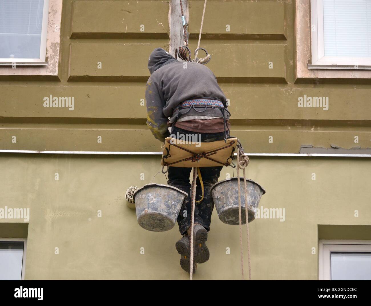 The man works on high-rise works cladding, plastering of the house ...