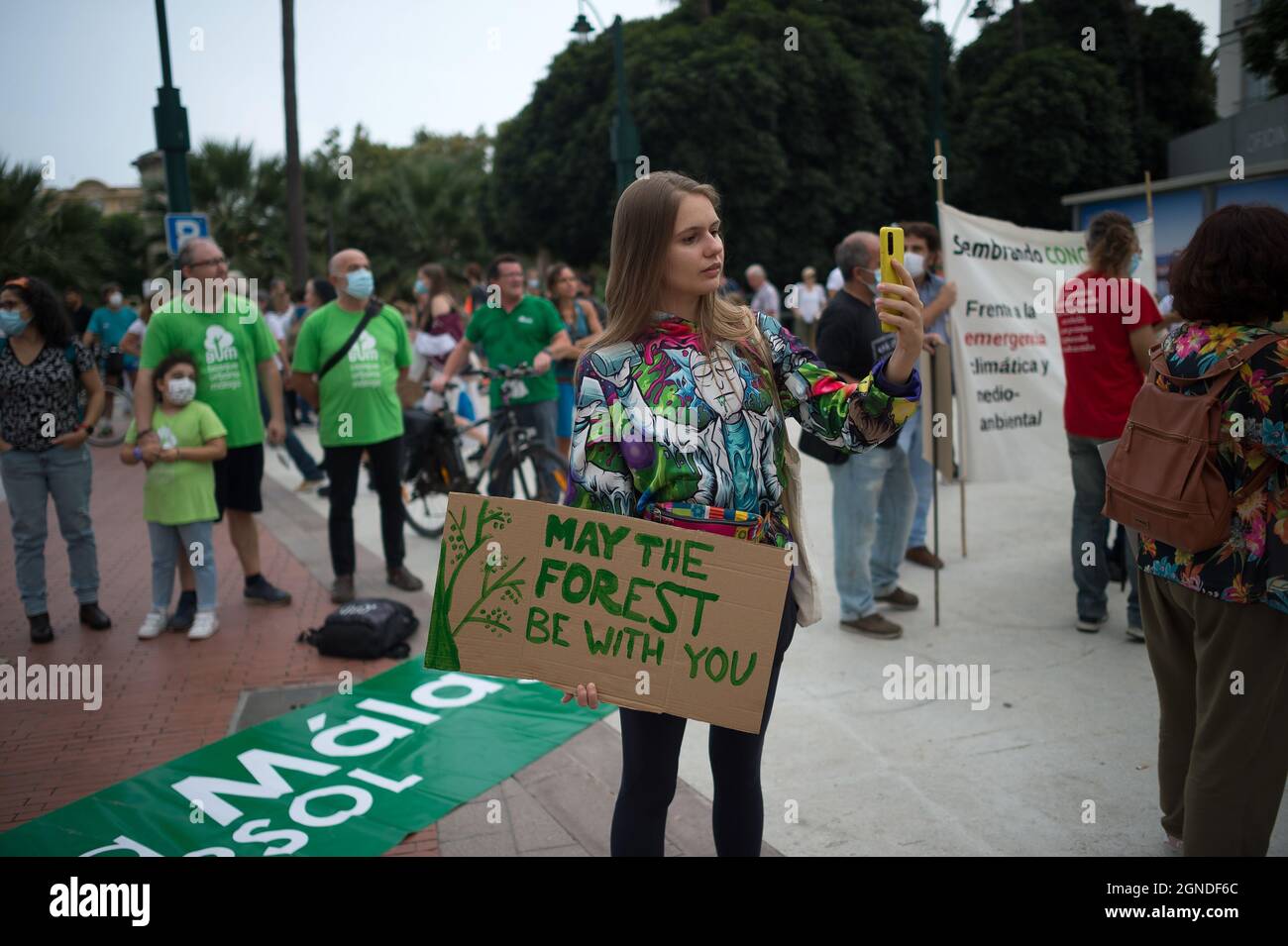 A climate activist holding a placard with a slogan expressing her ...