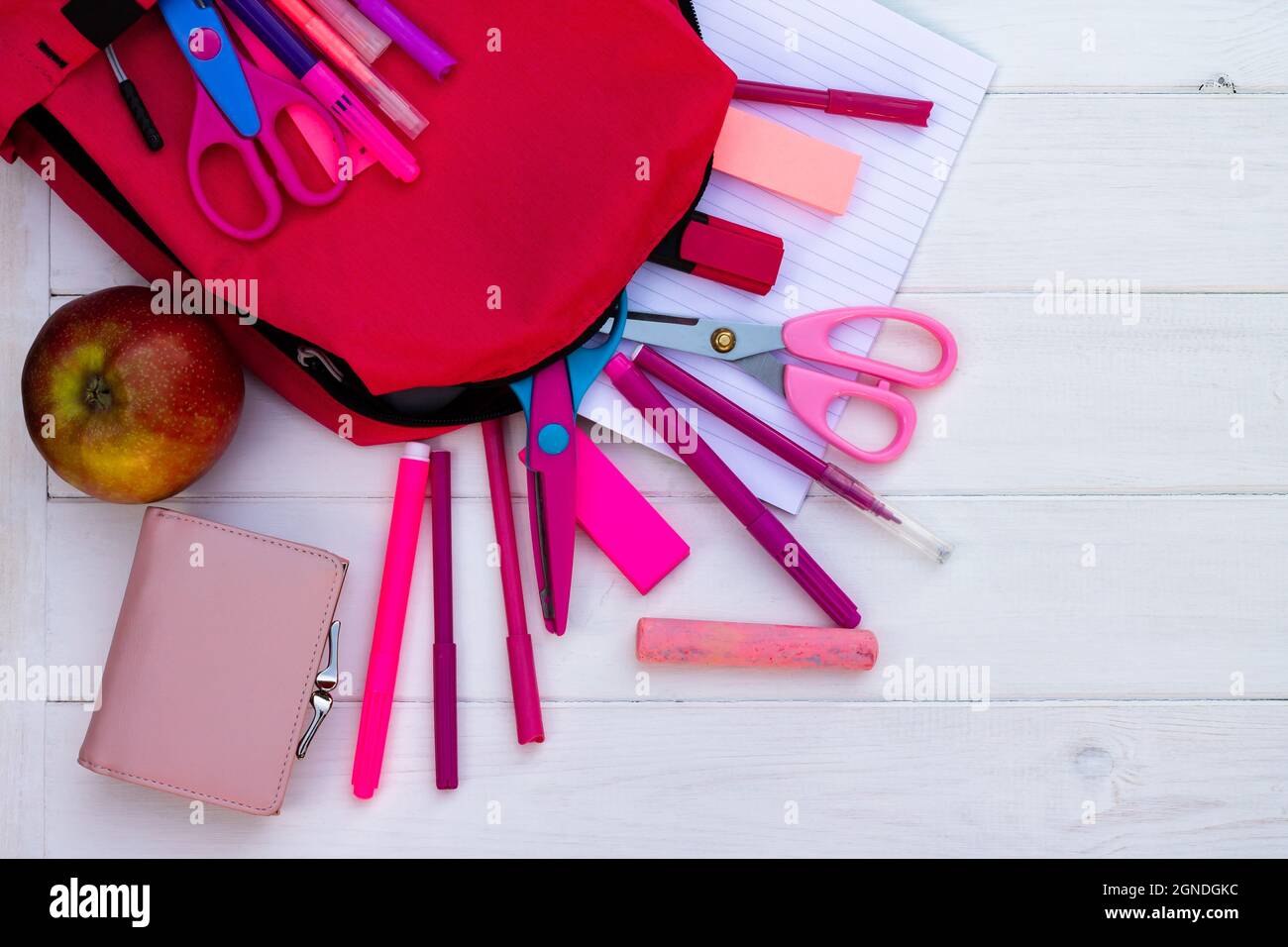Pink school supplies, backpack on a white wooden background. Top view ...