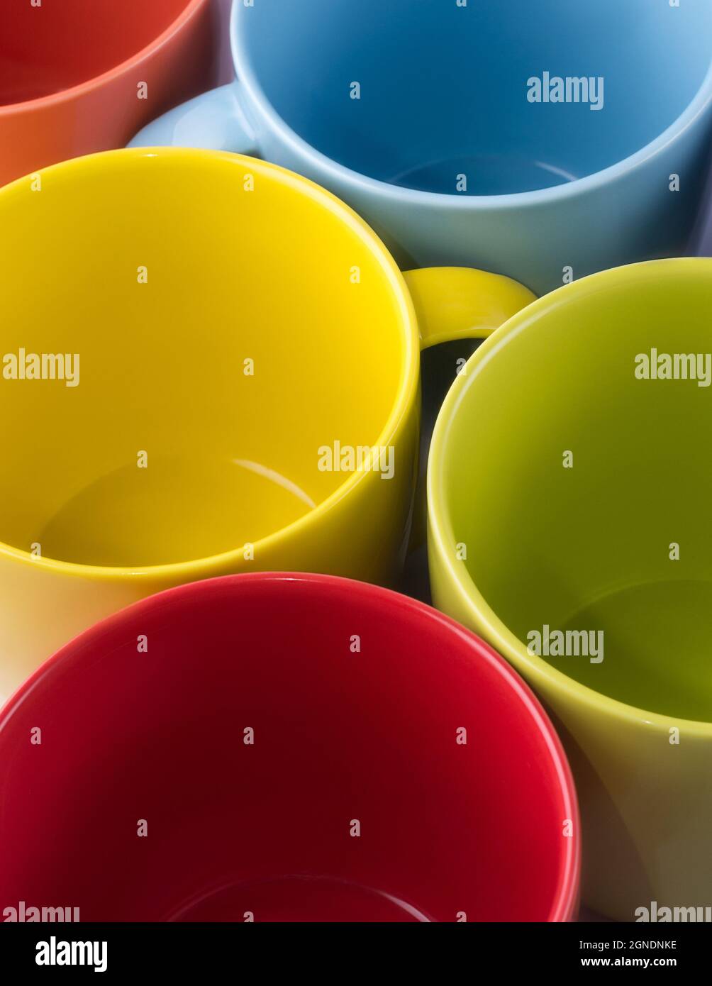 set of colorful ceramic cups, red, yellow, green, blue and orange color ...