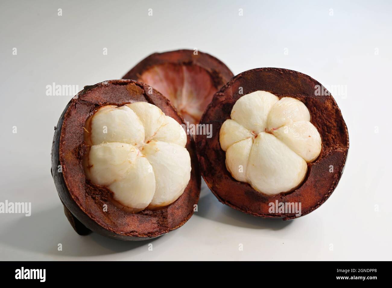 Two halves of an open mangosteen fruit & rind on white background Stock ...