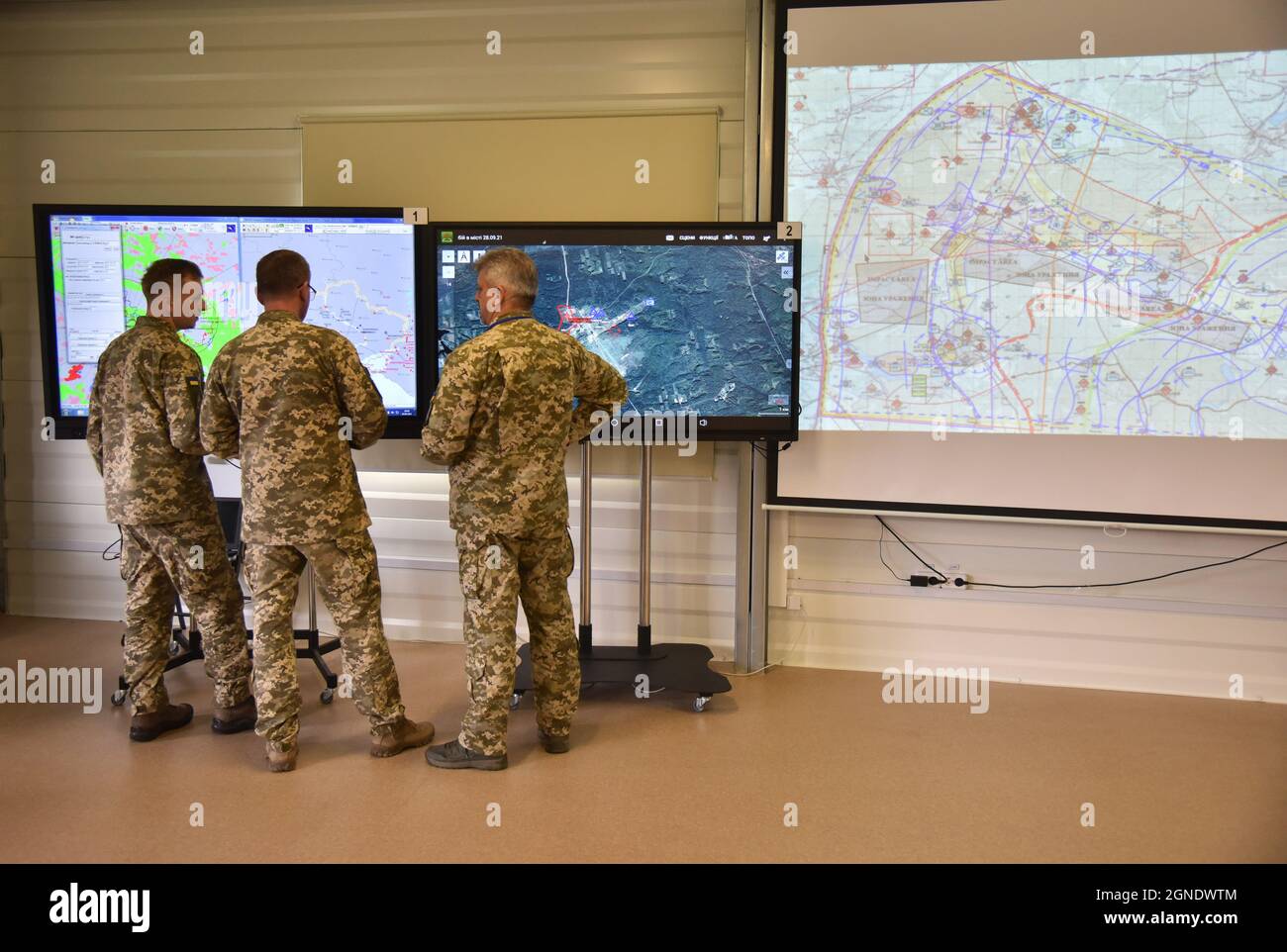 The military is seen behind monitor screens showing maps at the main ...