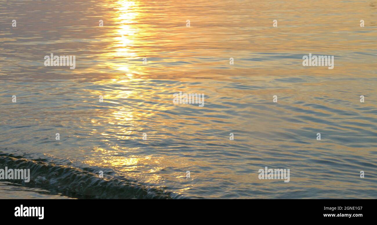Quiet sea waves washing shore at sunset Stock Photo - Alamy