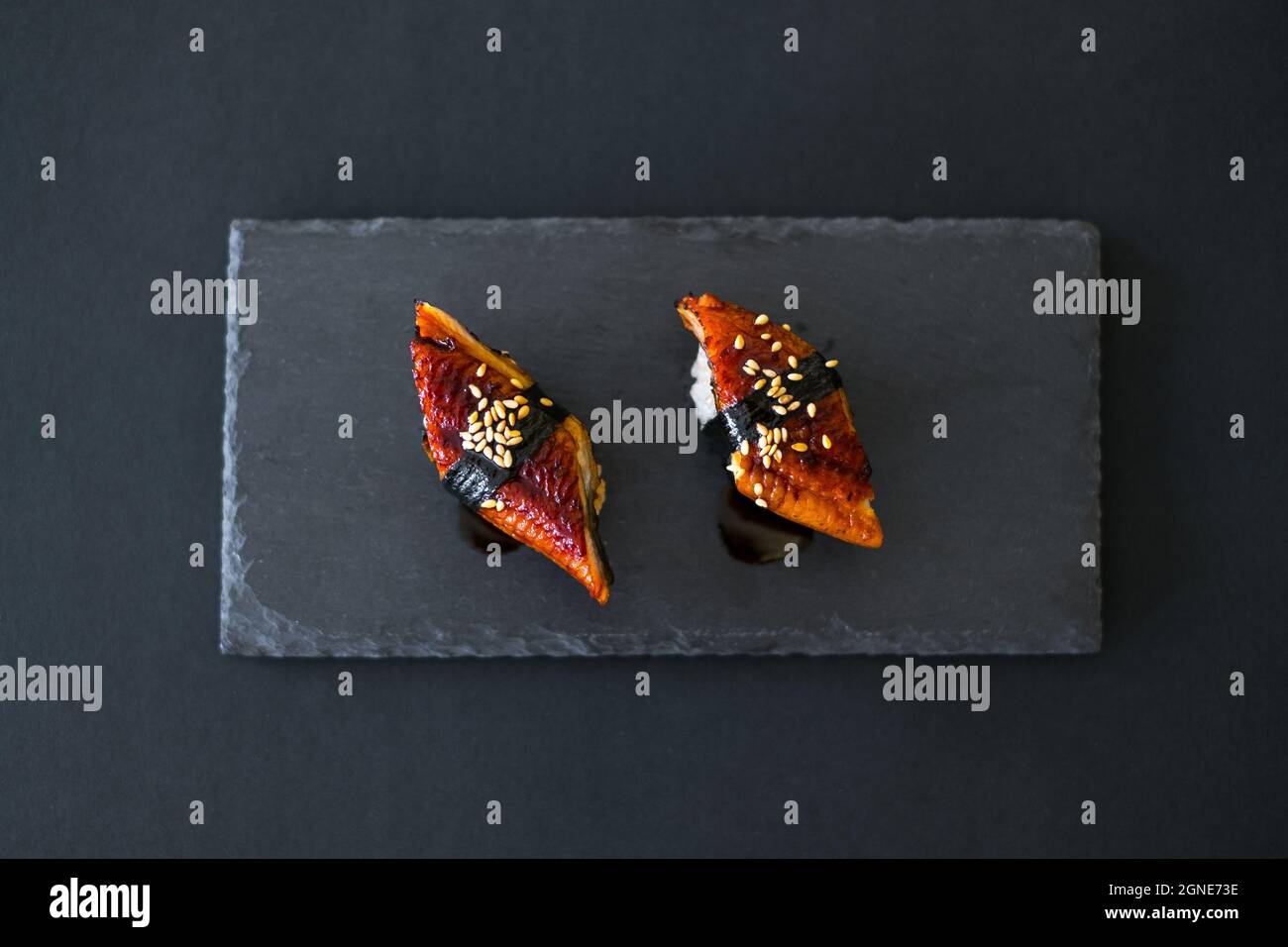 Japanese Sushi - Two Unagi Nigiri Sushi on black stone board. Sushi pieces served on black slate ...