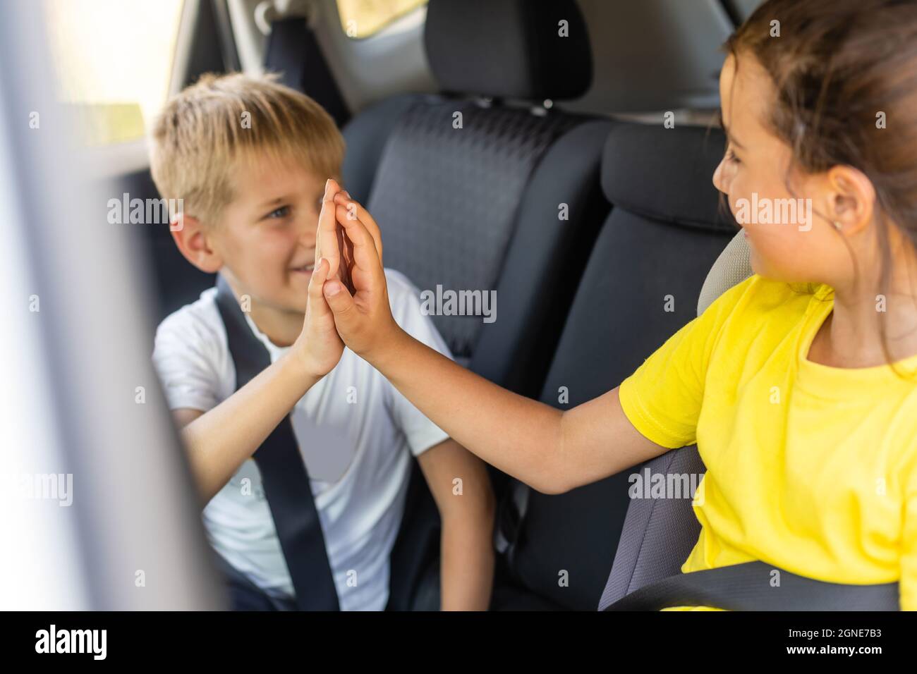 Smiling kids sitting on back seat of car Stock Photo - Alamy