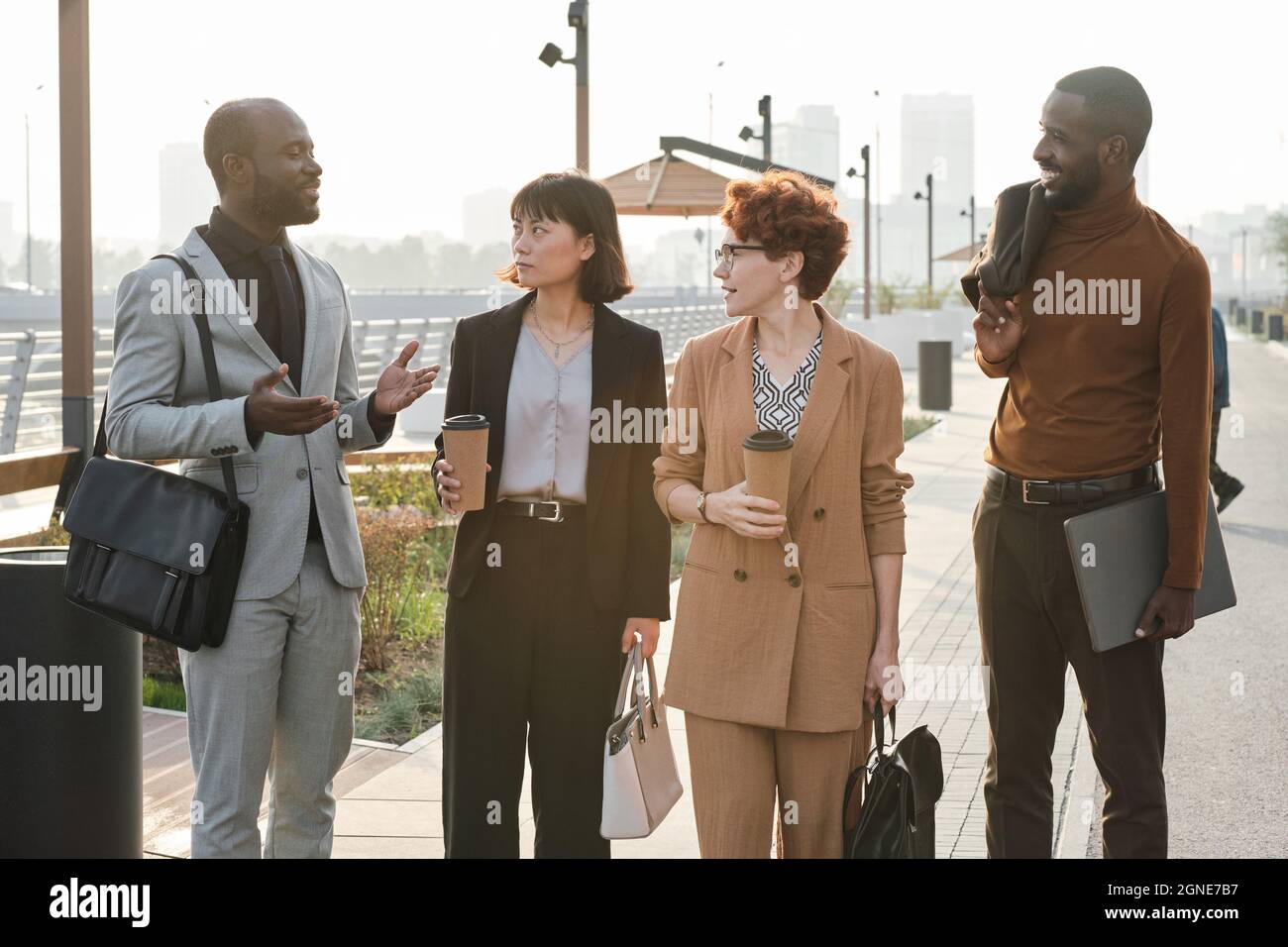 Horizontal medium long shot of four young multi-ethnic men and women ...