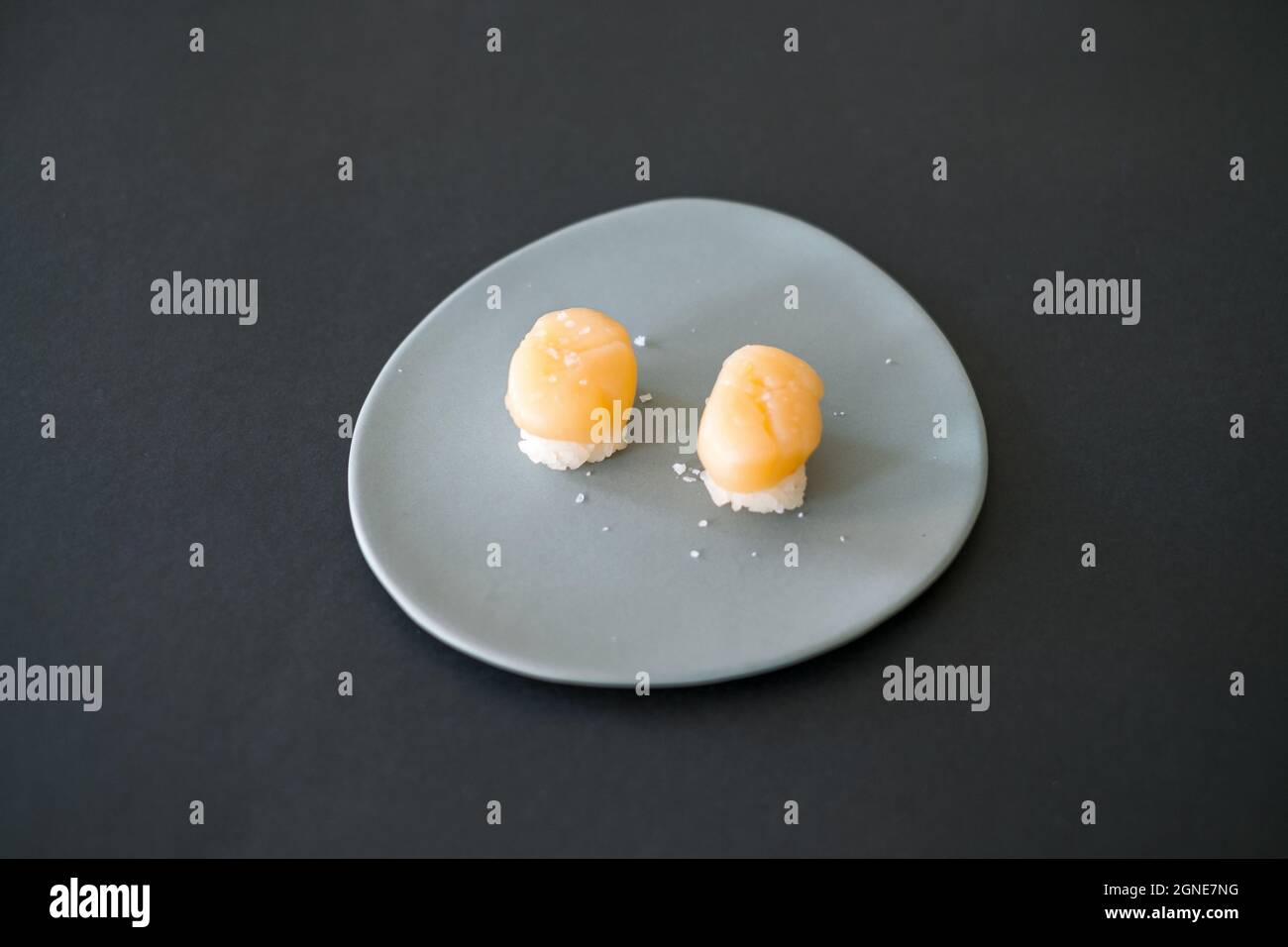 Two Nigiri Sushi with scallop in restaurant served on light-grey plate ...
