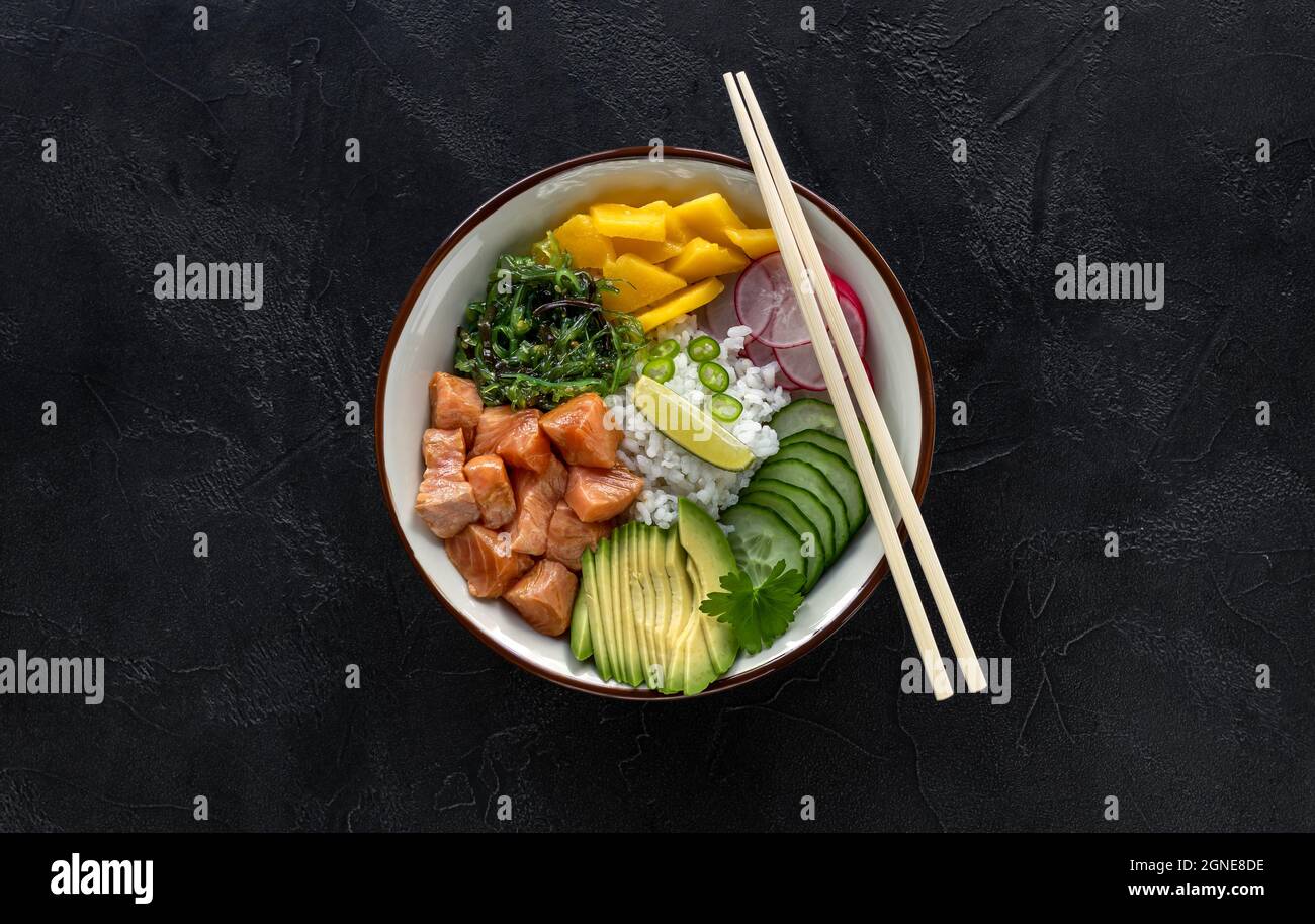 Hawaiian salmon fish poke bowl with rice, mango, radish, cucumber ...