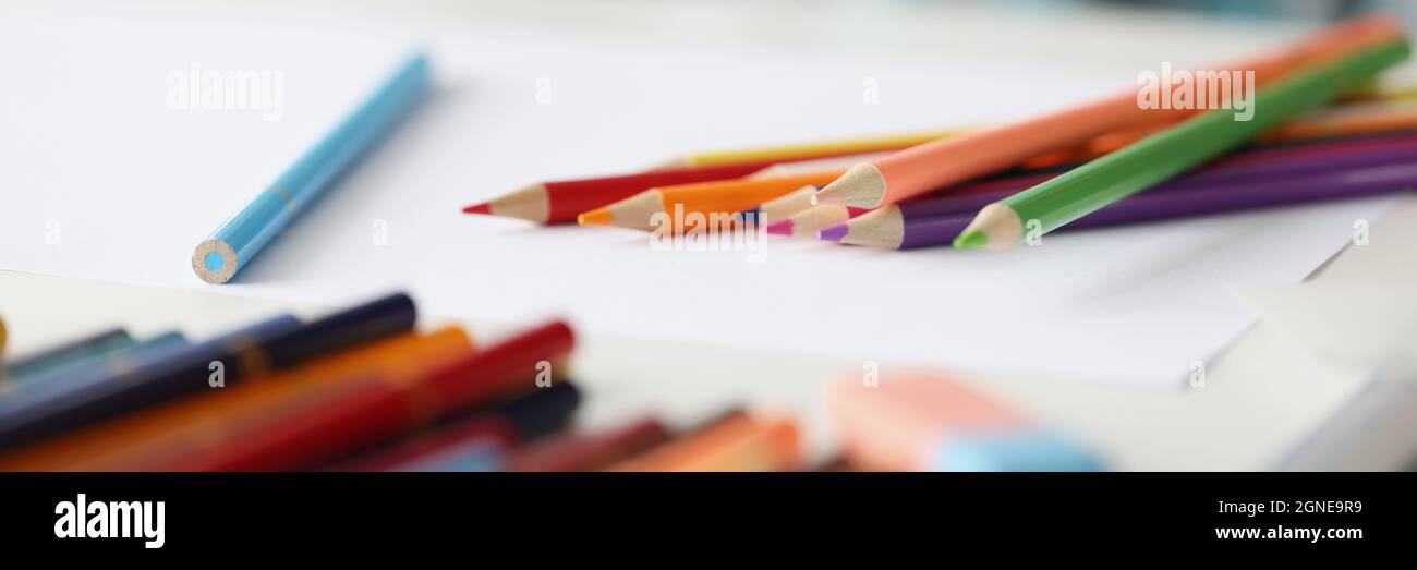 Many multi-colored pencils lying on blank sheet of paper closeup Stock ...